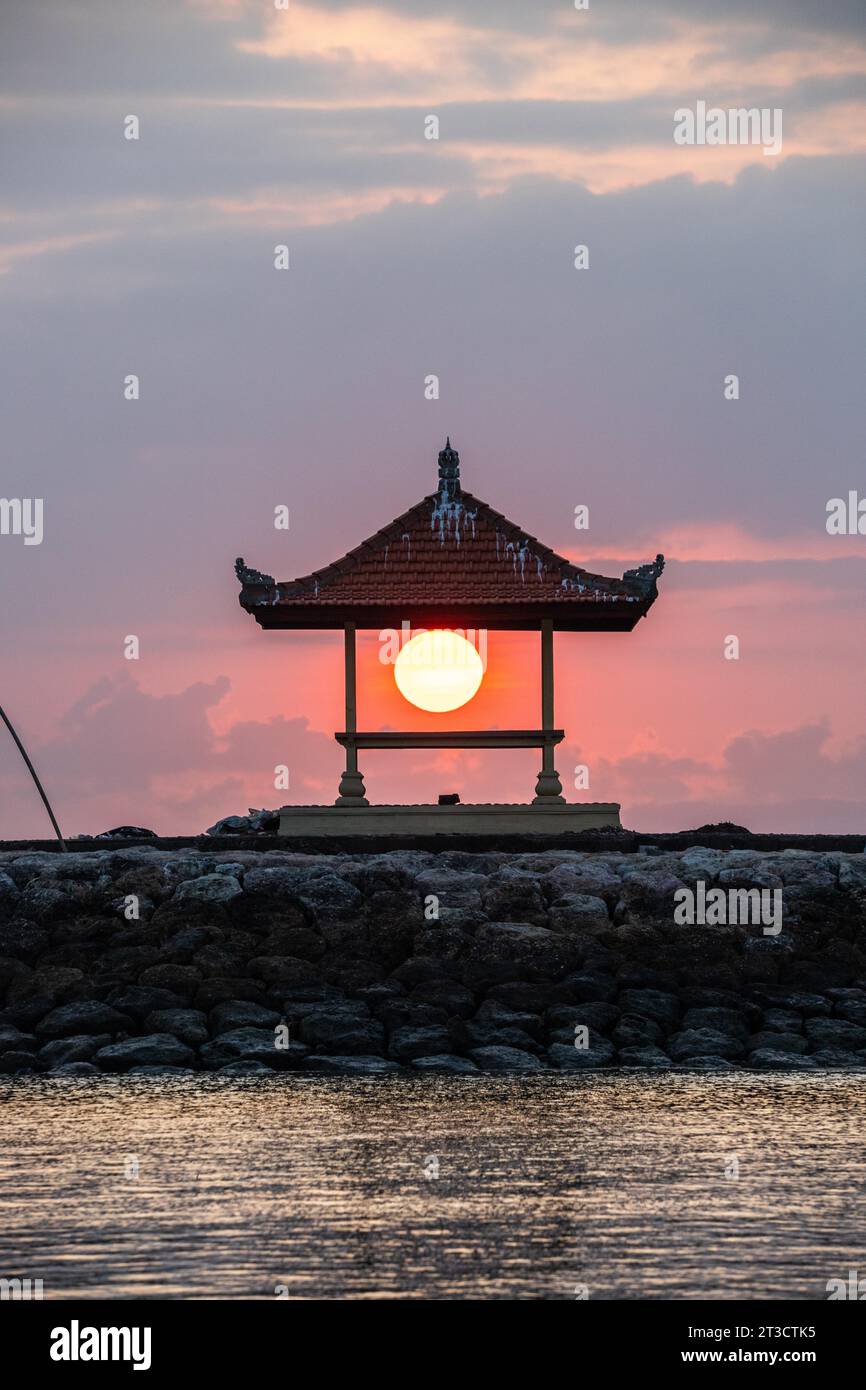 Sunrise on sandy beach with small temples in the water. Landscape shot ...