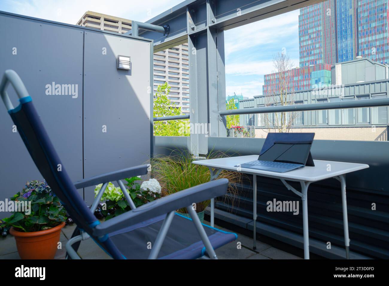 work from home concept, a desk with laptop and flowers on a terrace ...