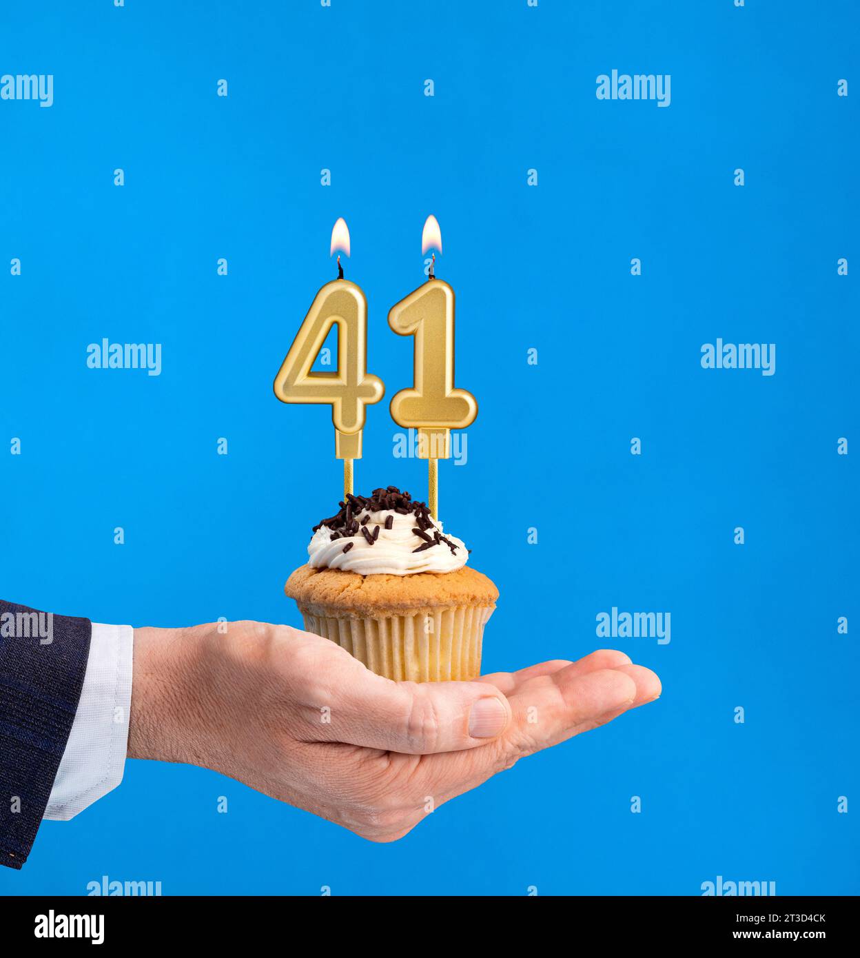 Hand holding a cupcake with the number 41 candle - Birthday on blue ...