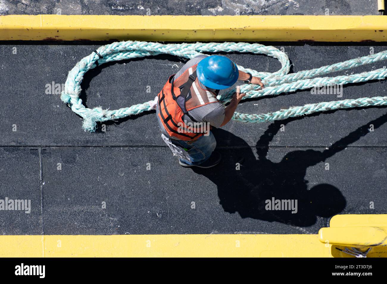 Overhead shot of a worker wearing a reflective vest and blue helmet ...
