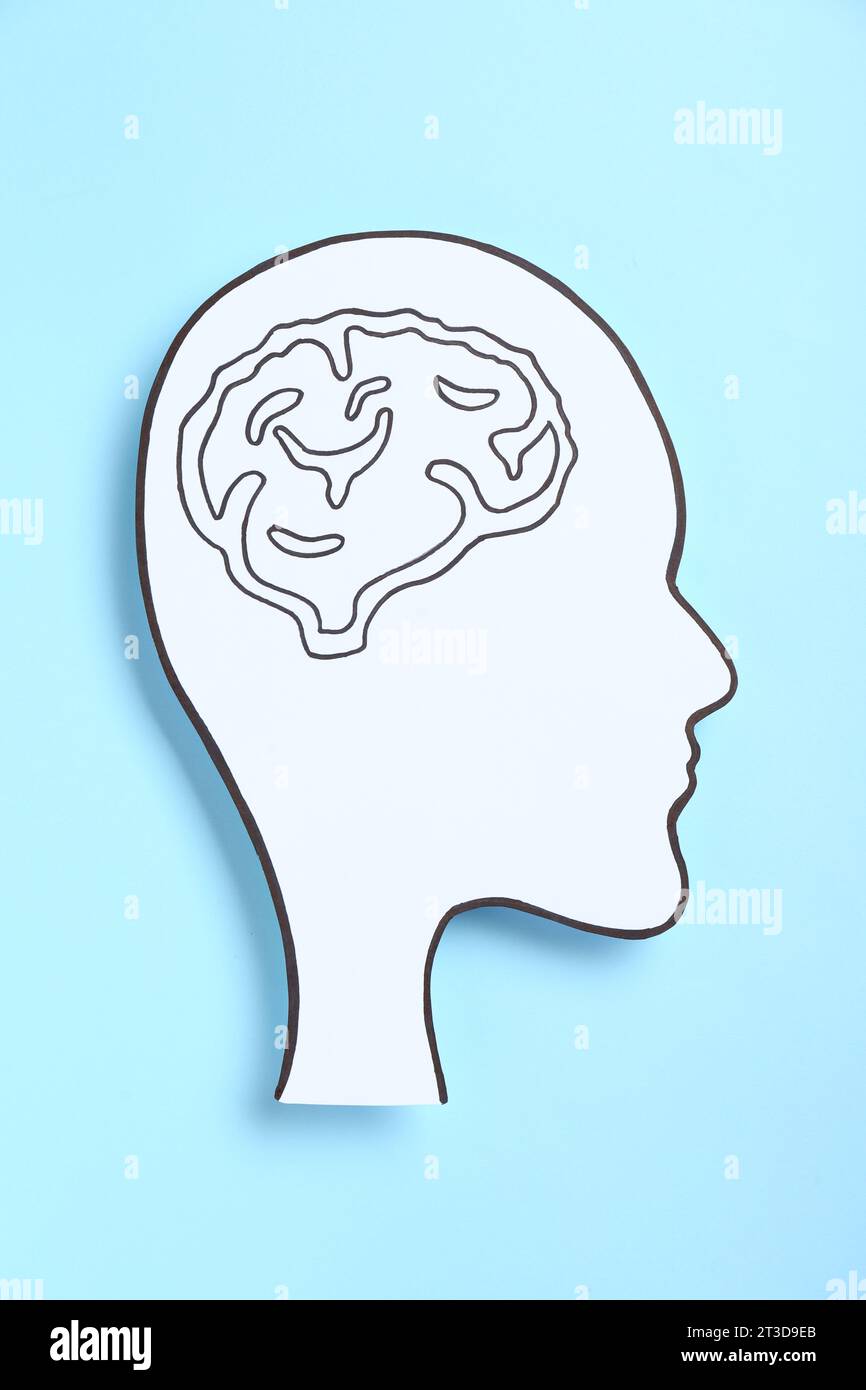 Paper human head cutout with drawing of brain on light blue background ...