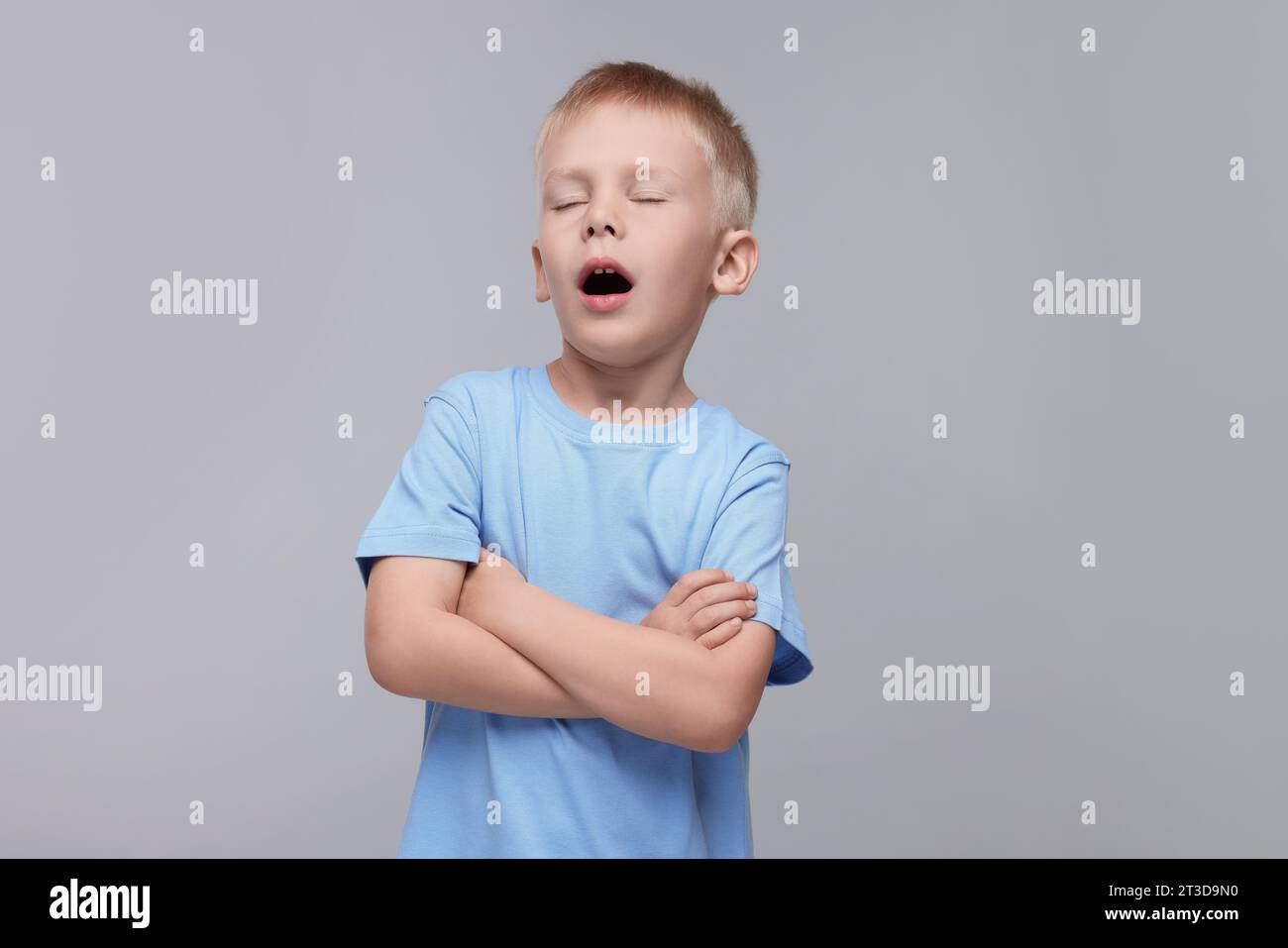 Sleepy boy yawning on light grey background. Insomnia problem Stock ...