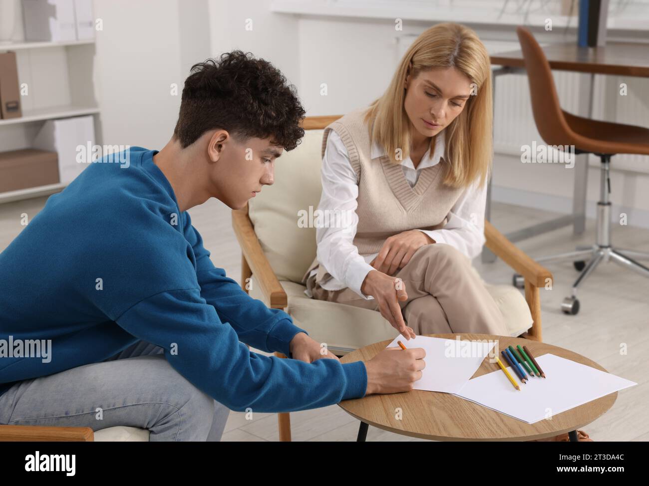 Psychologist working with teenage boy in office. Teenager problems ...