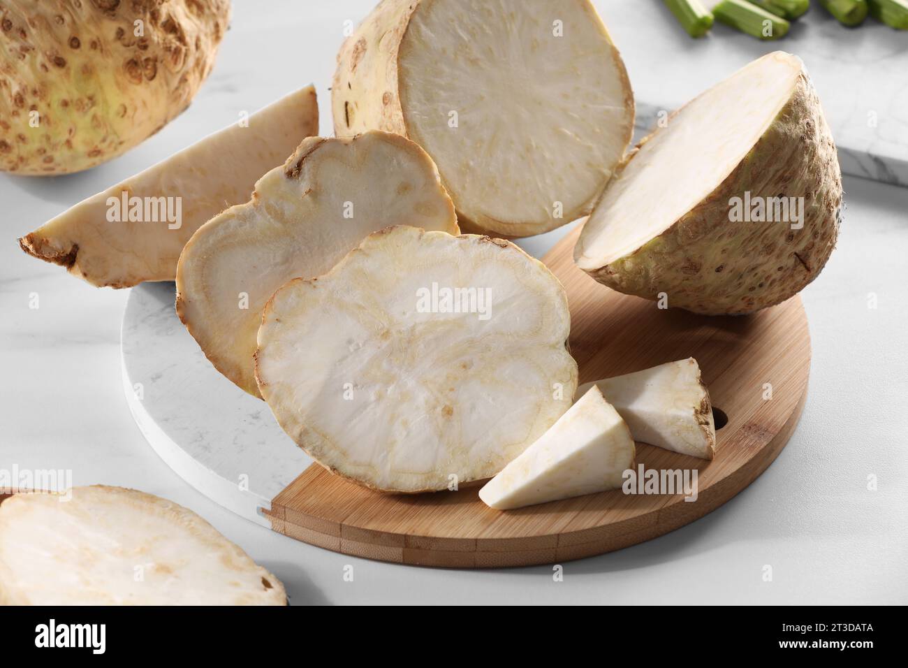 Cut celery roots on white marble table Stock Photo - Alamy