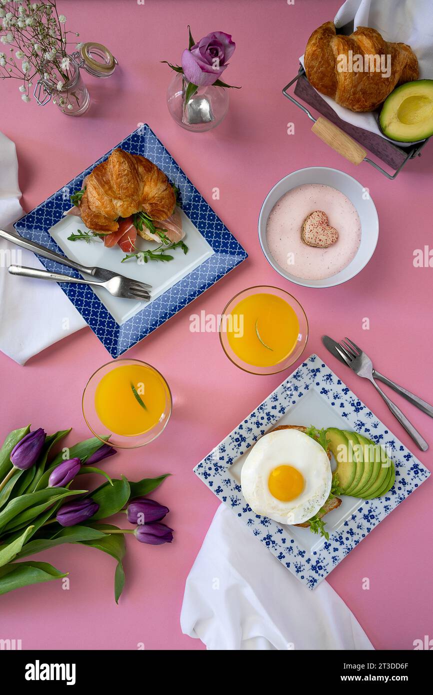 Top view of a brunch table setting with food. Beautiful pink background ...