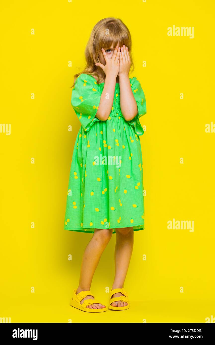 Nosy curious blonde child girl kid closing eyes with hands, spying ...