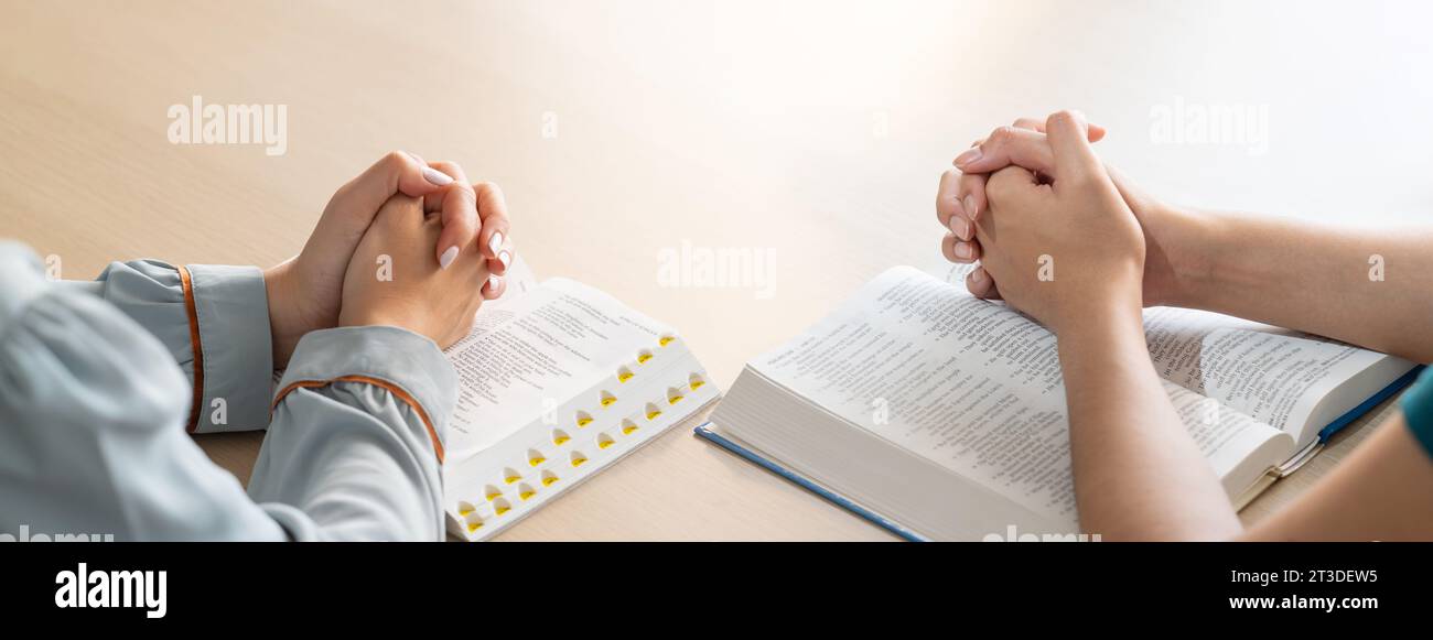 Two believer praying together on holy bible book faithfully with wooden ...