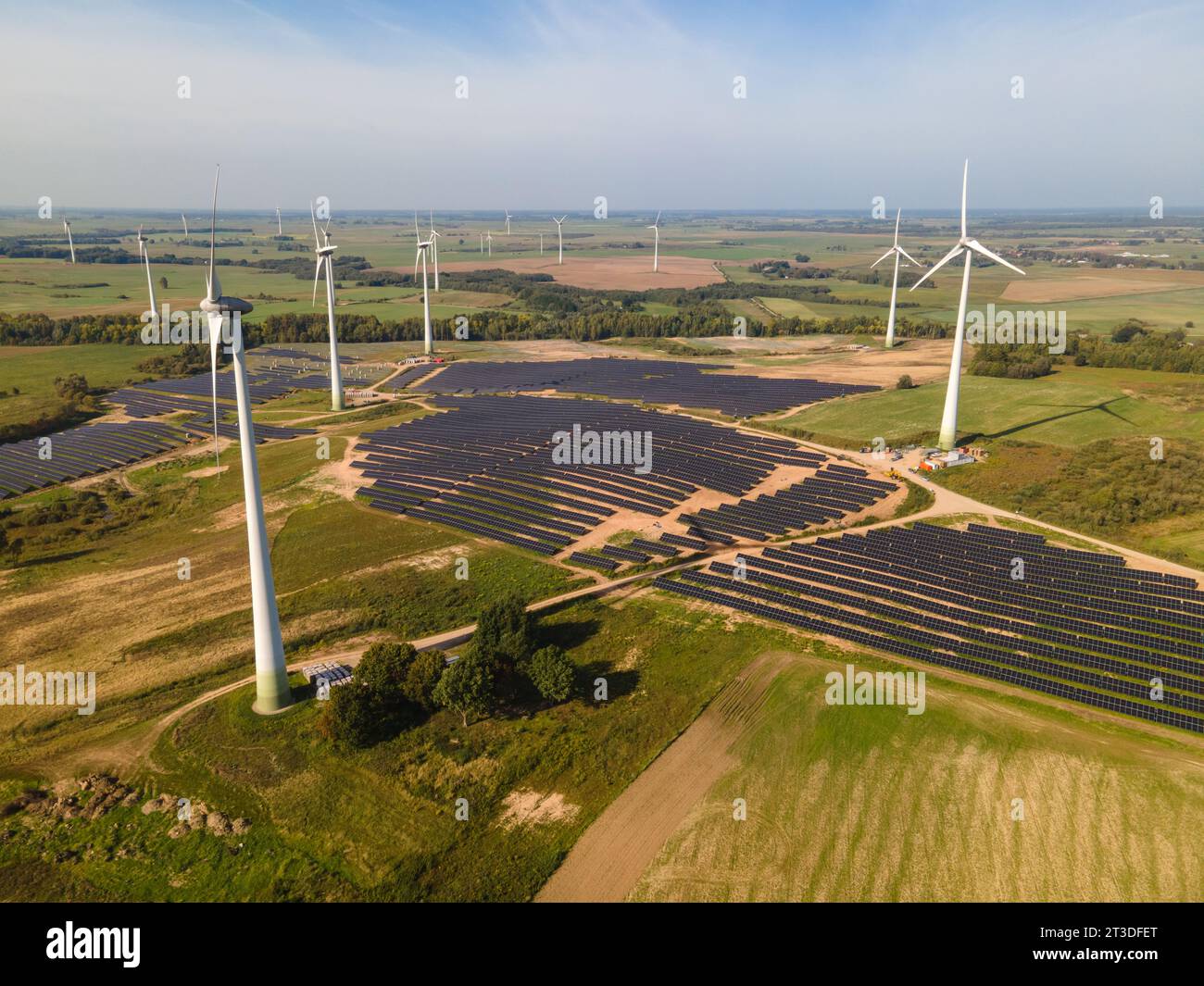 A scenic view of a solar farm featuring a cluster of wind turbines ...