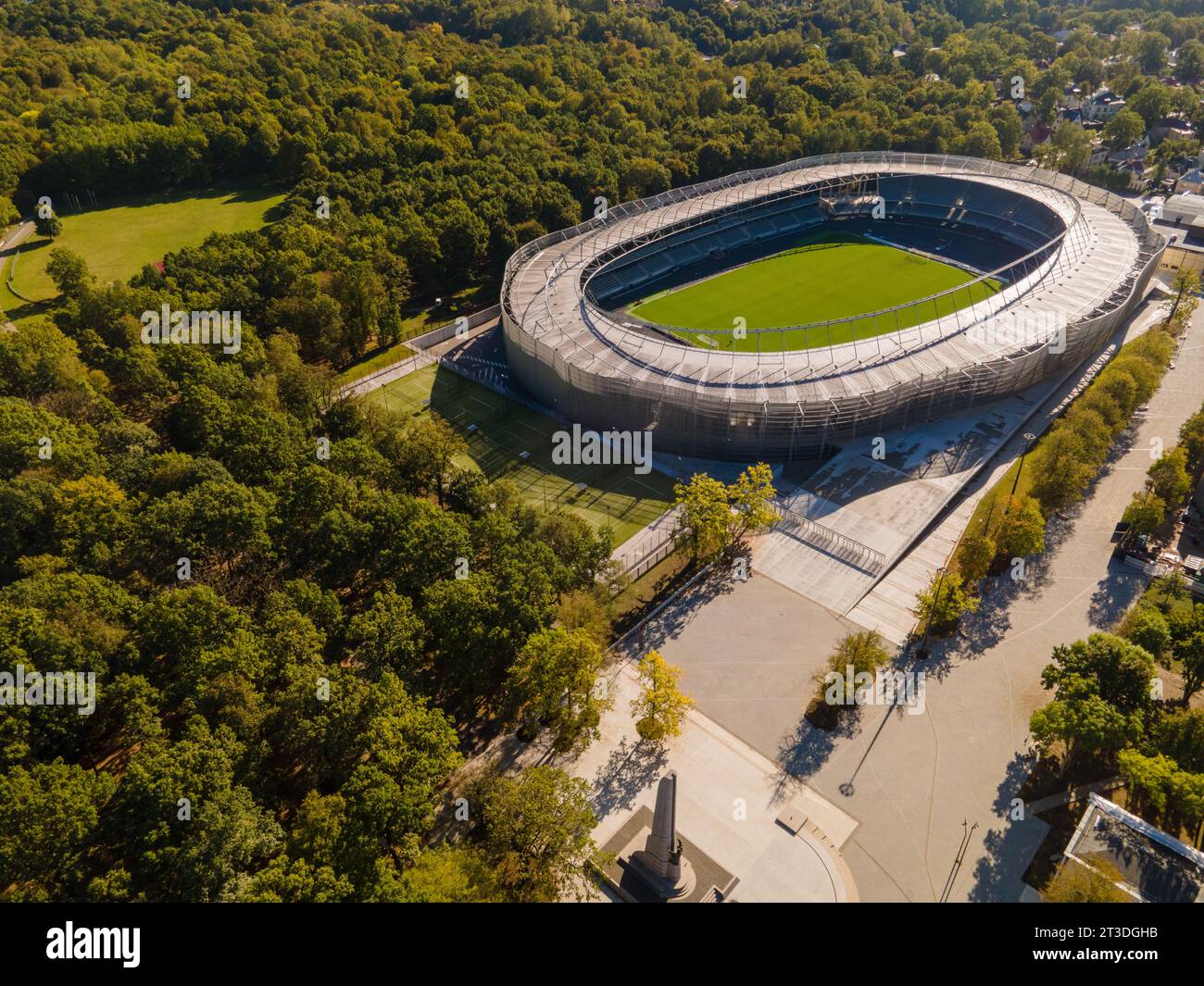 An aerial view of a soccer field and stadium in a grassy, tree-filled ...