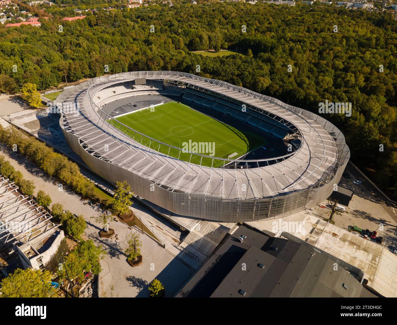 An aerial view of a soccer field and stadium in a grassy, tree-filled ...