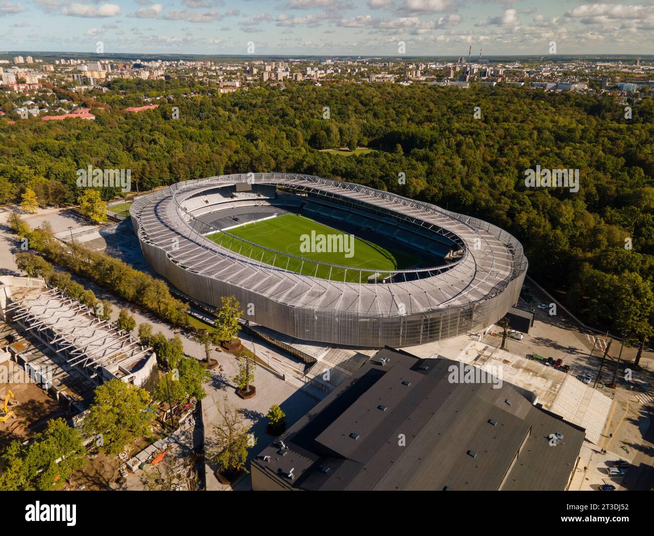 An aerial view of a soccer field and stadium in a grassy, tree-filled ...