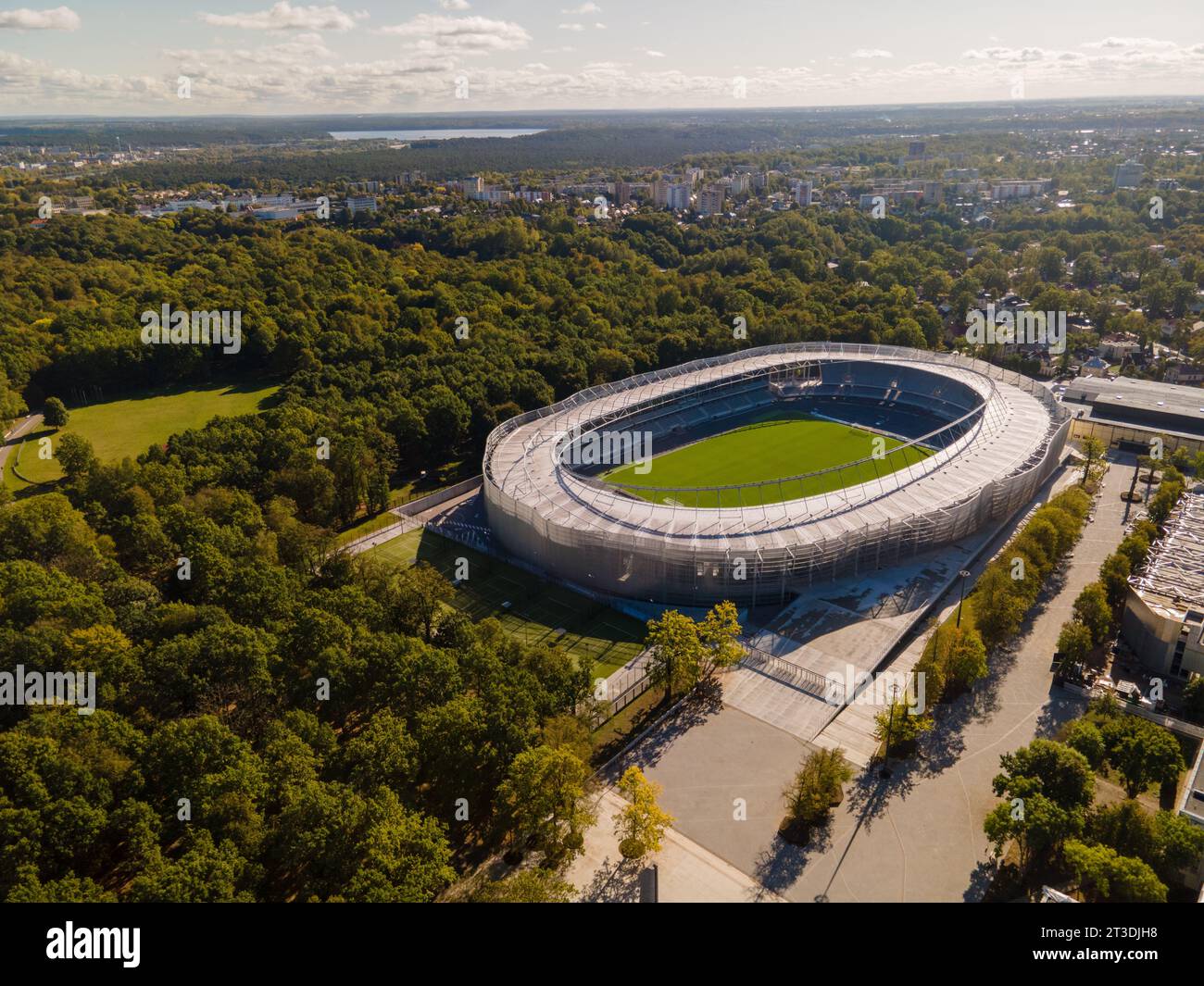 An aerial view of a soccer field and stadium in a grassy, tree-filled ...