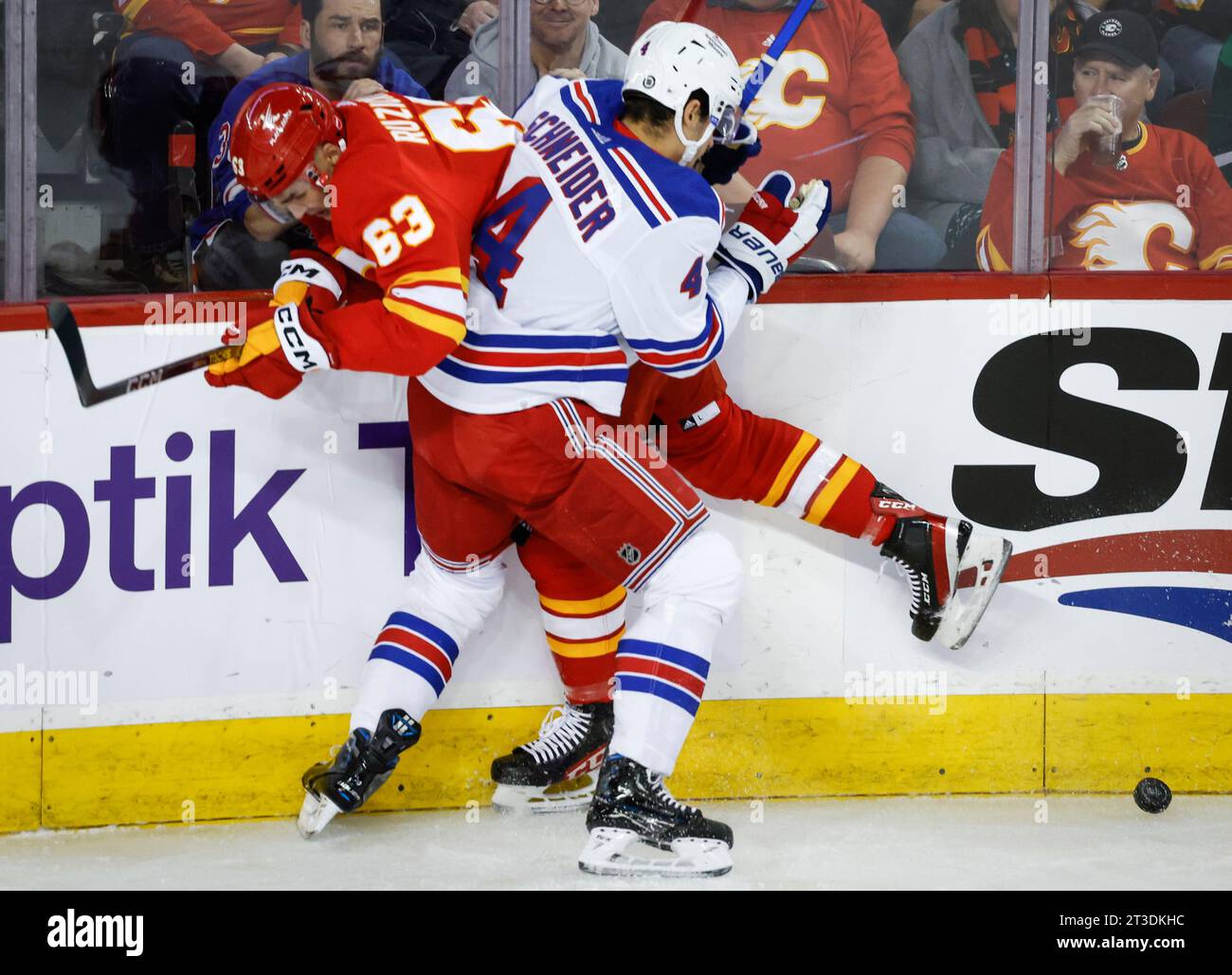 New York Rangers defenseman Braden Schneider, right, checks Calgary ...