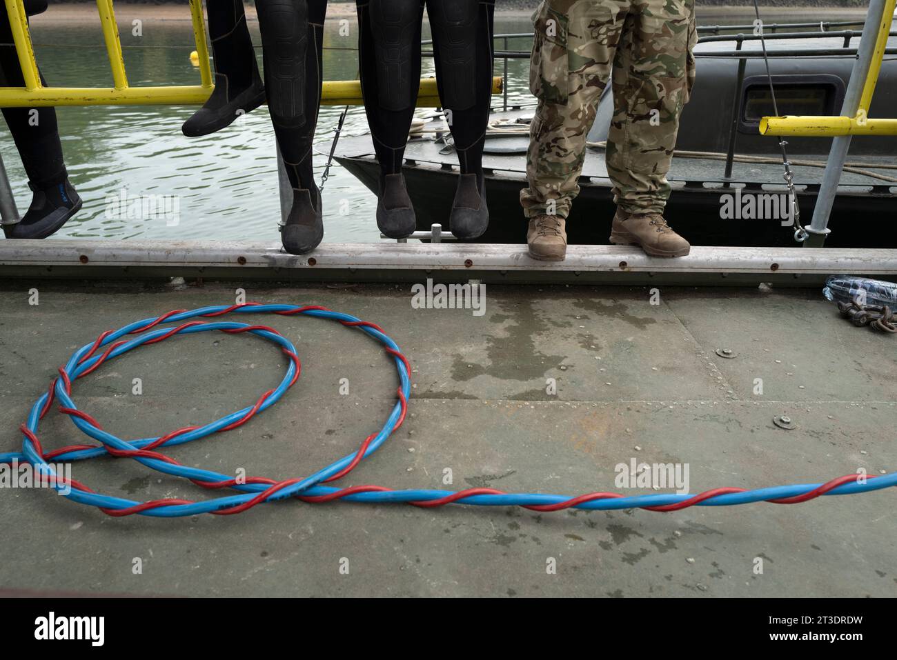 Diving suits and a supporting soldier are seen behind an oxygen pipe ...