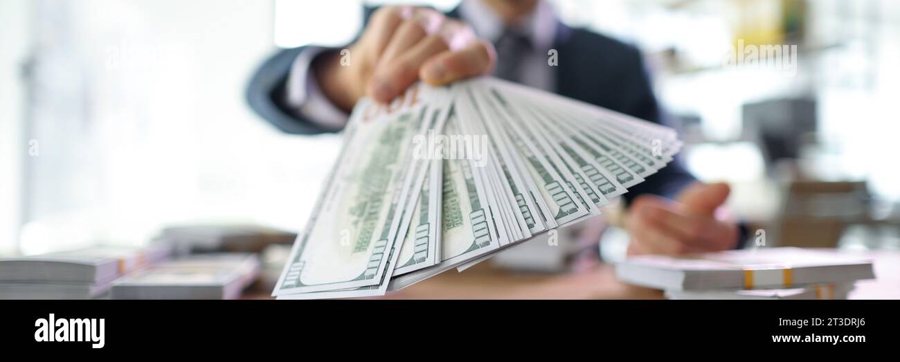 Happy businessman holds money fan above dollar banknotes Stock Photo ...
