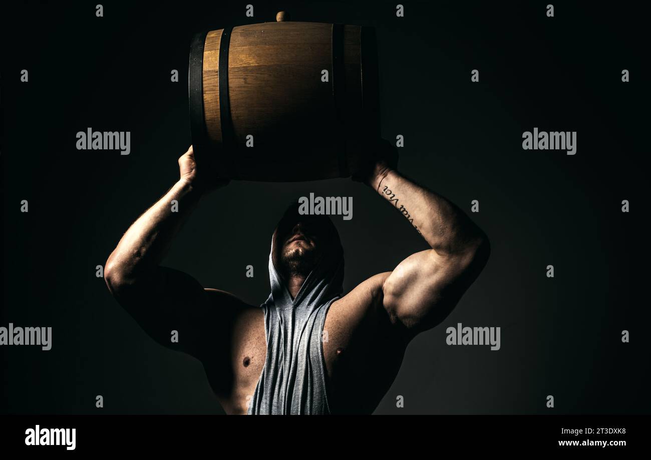 Muscular man wooden barrel on black. Brutal brewer man. Brewery concept ...