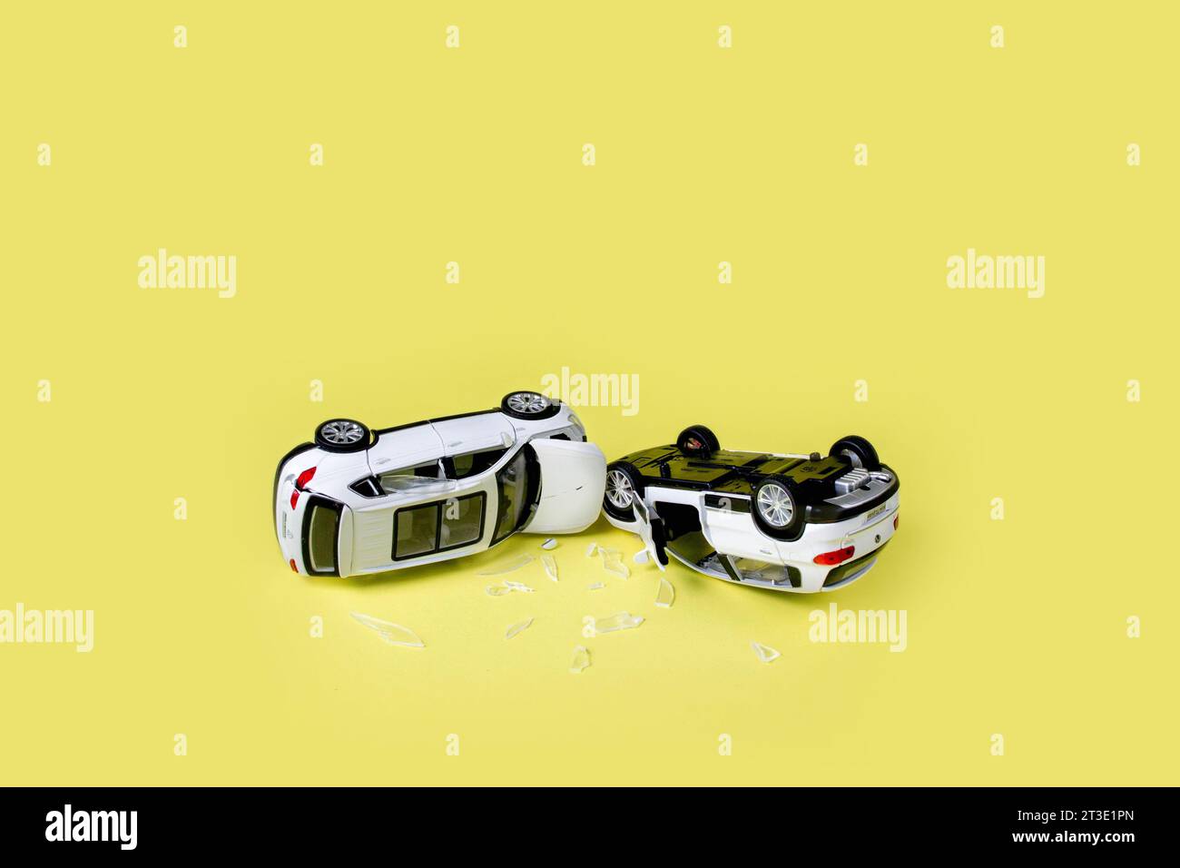 Two mini toy car crash on yellow background, incident, car traffic ...
