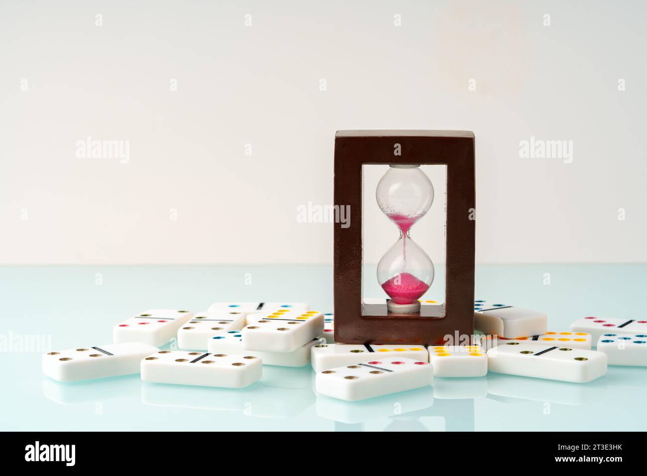 Hourglass and domino tiles on blue background. Time limit concept Stock ...