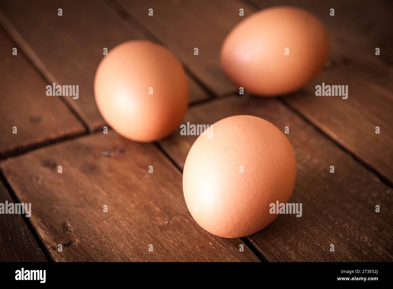 Tree fresh eggs on a rustic wooden board background Stock Photo - Alamy