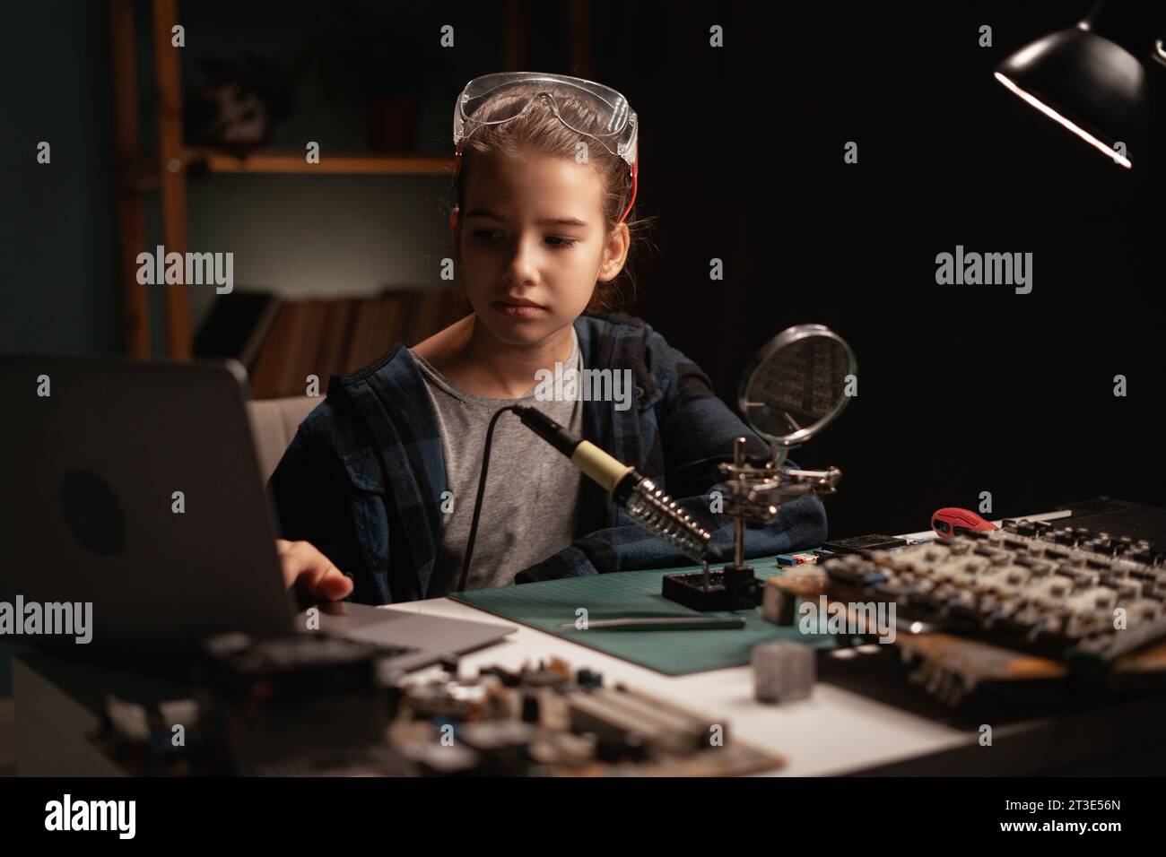 Teen girl learns electronics and soldering wires on an old circuit ...