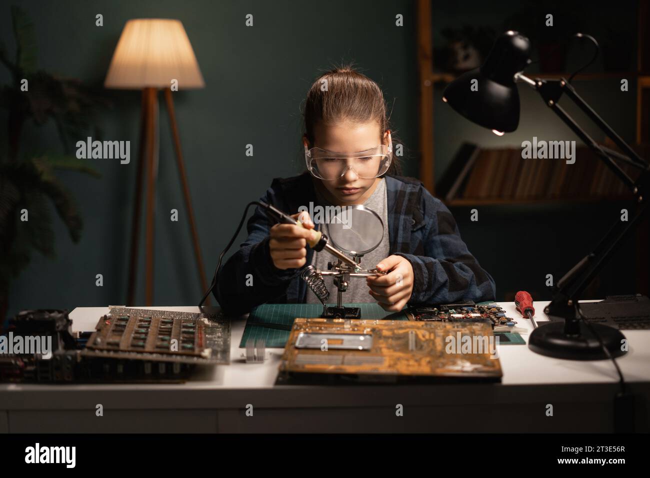 Smart young teenage girl studying electronics soldering wires and ...
