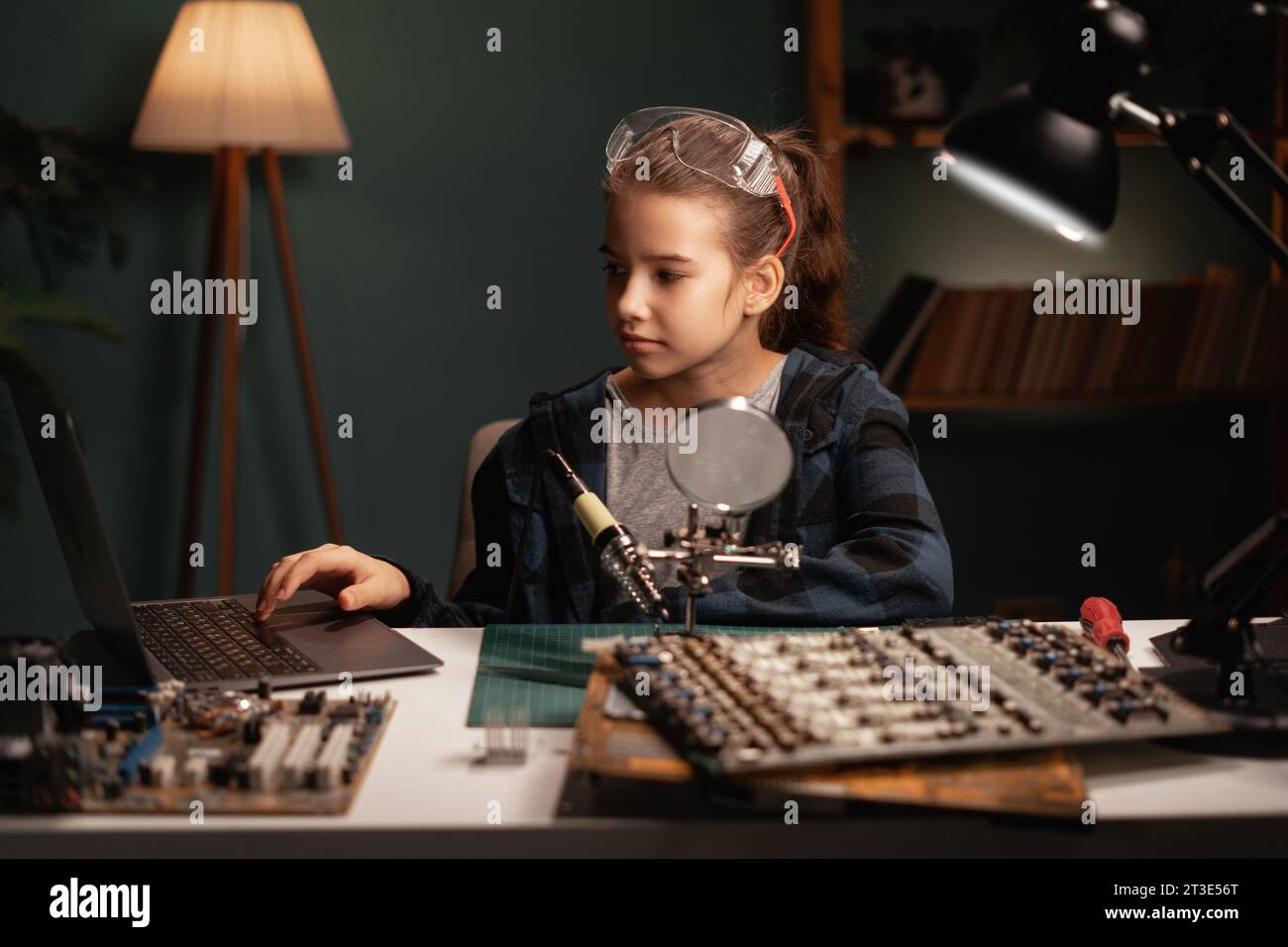 Cute intelligent girl is passionate about repair a motherboard, doing ...