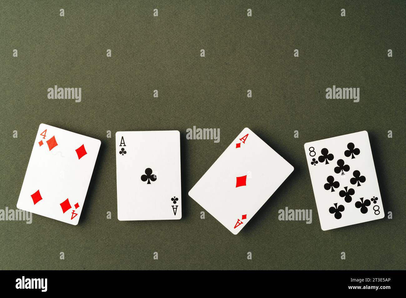 Playing cards on green background studio shot Stock Photo - Alamy