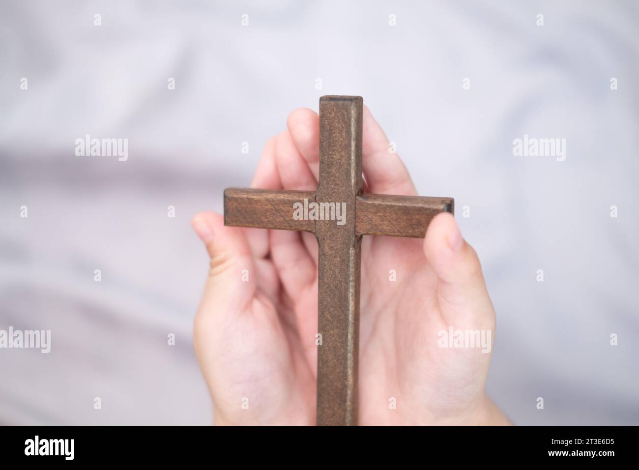 The boy's hands are holding a cross Stock Photo - Alamy