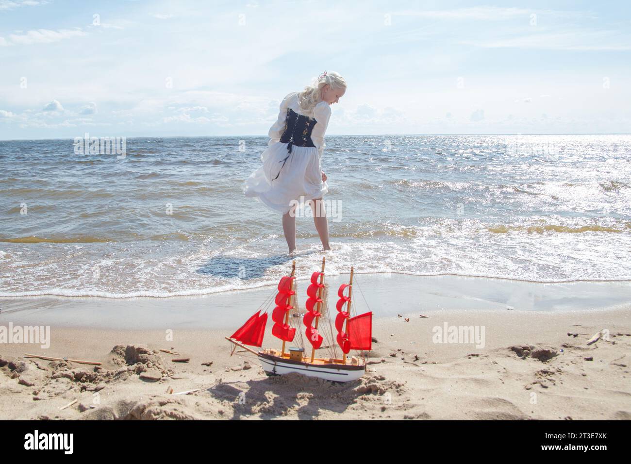 Beautiful young lady walking along the seashore Stock Photo - Alamy
