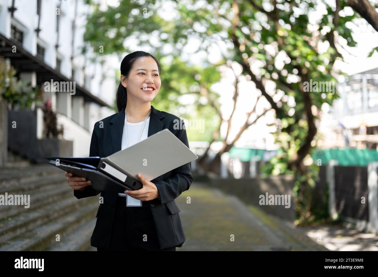 A successful and happy millennial Asian businesswoman in a formal ...