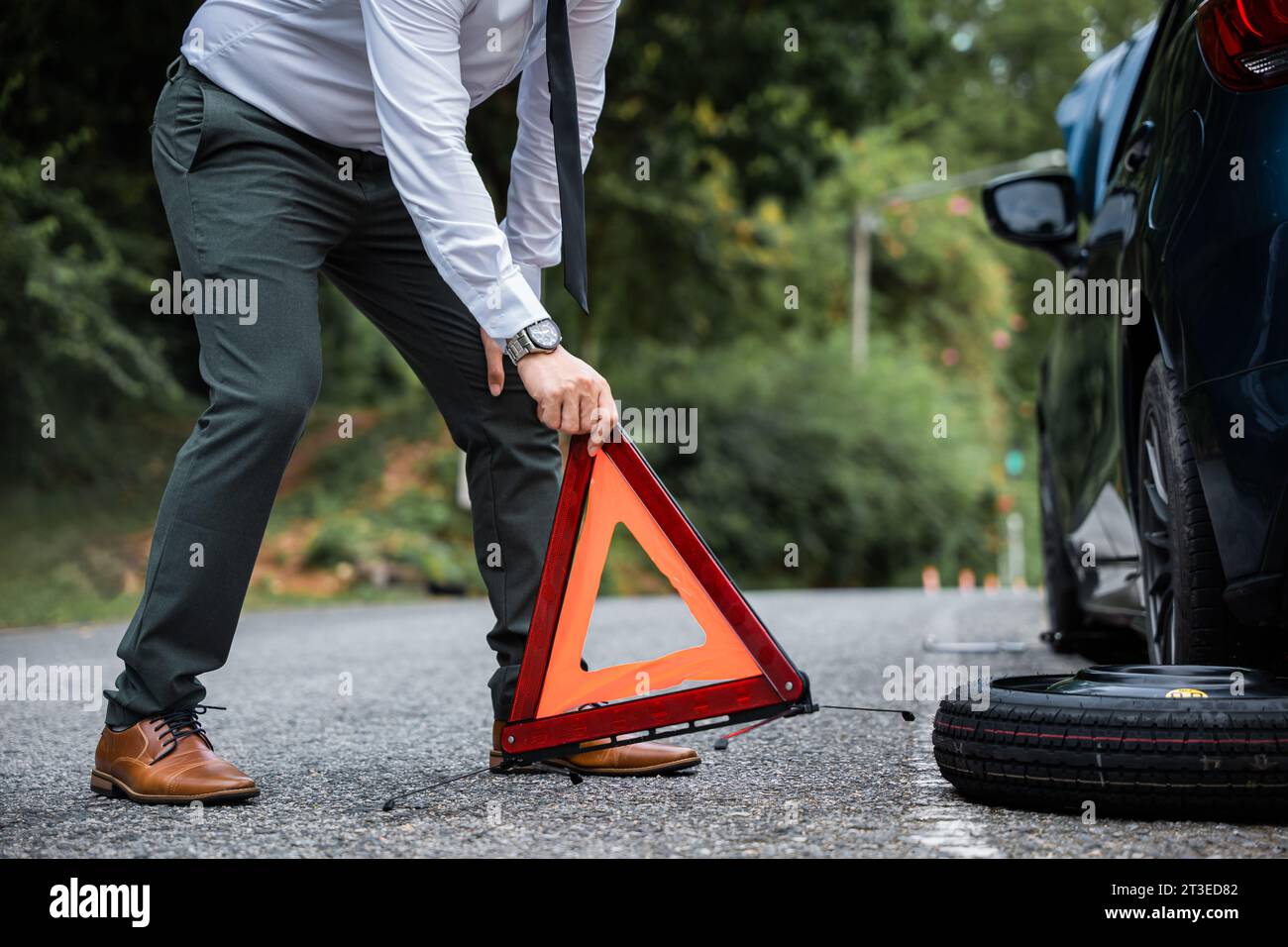 Man take down red warning triangle Stock Photo - Alamy