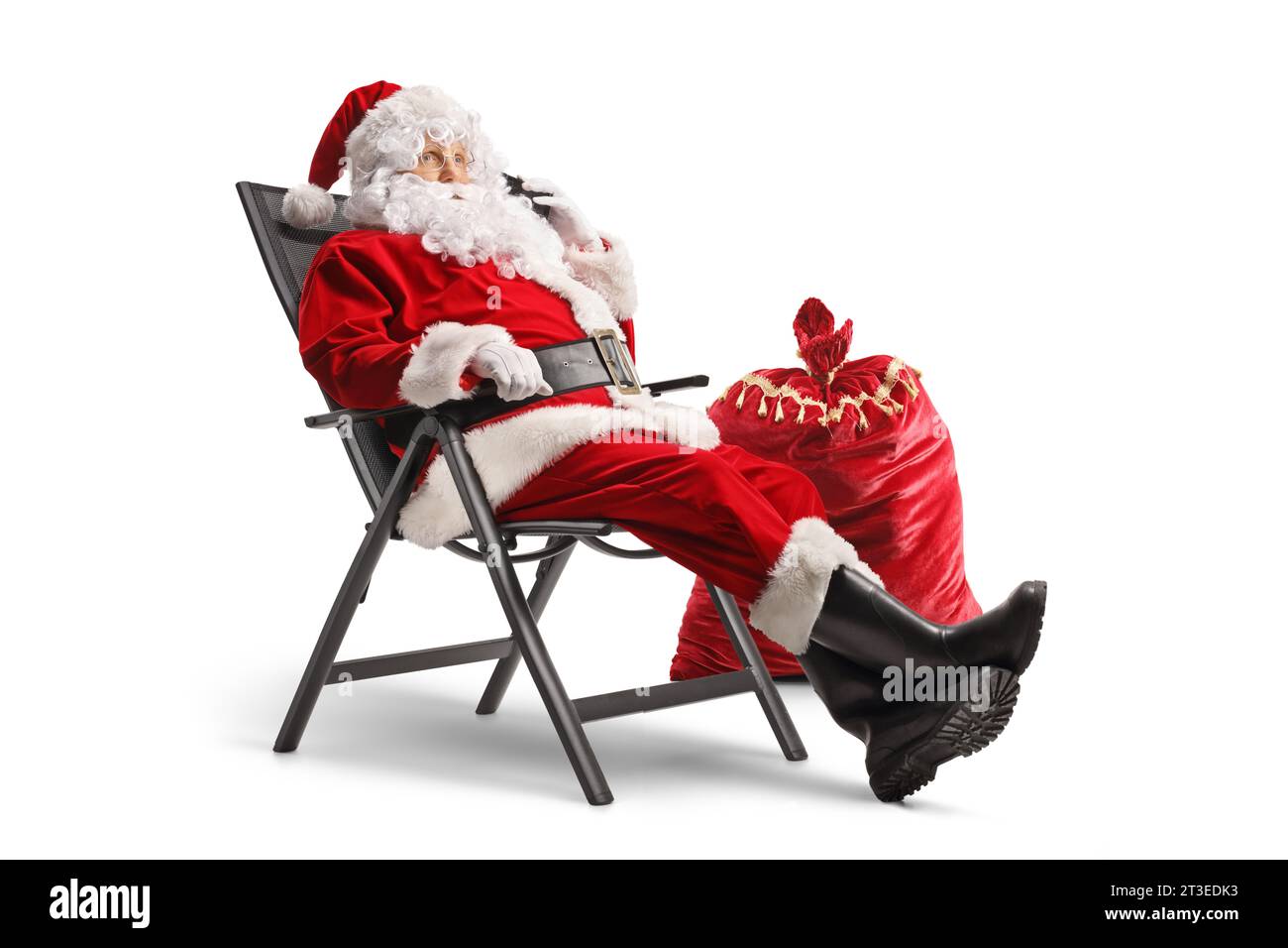 Santa claus sitting in a foldable chair and making a phone call ...