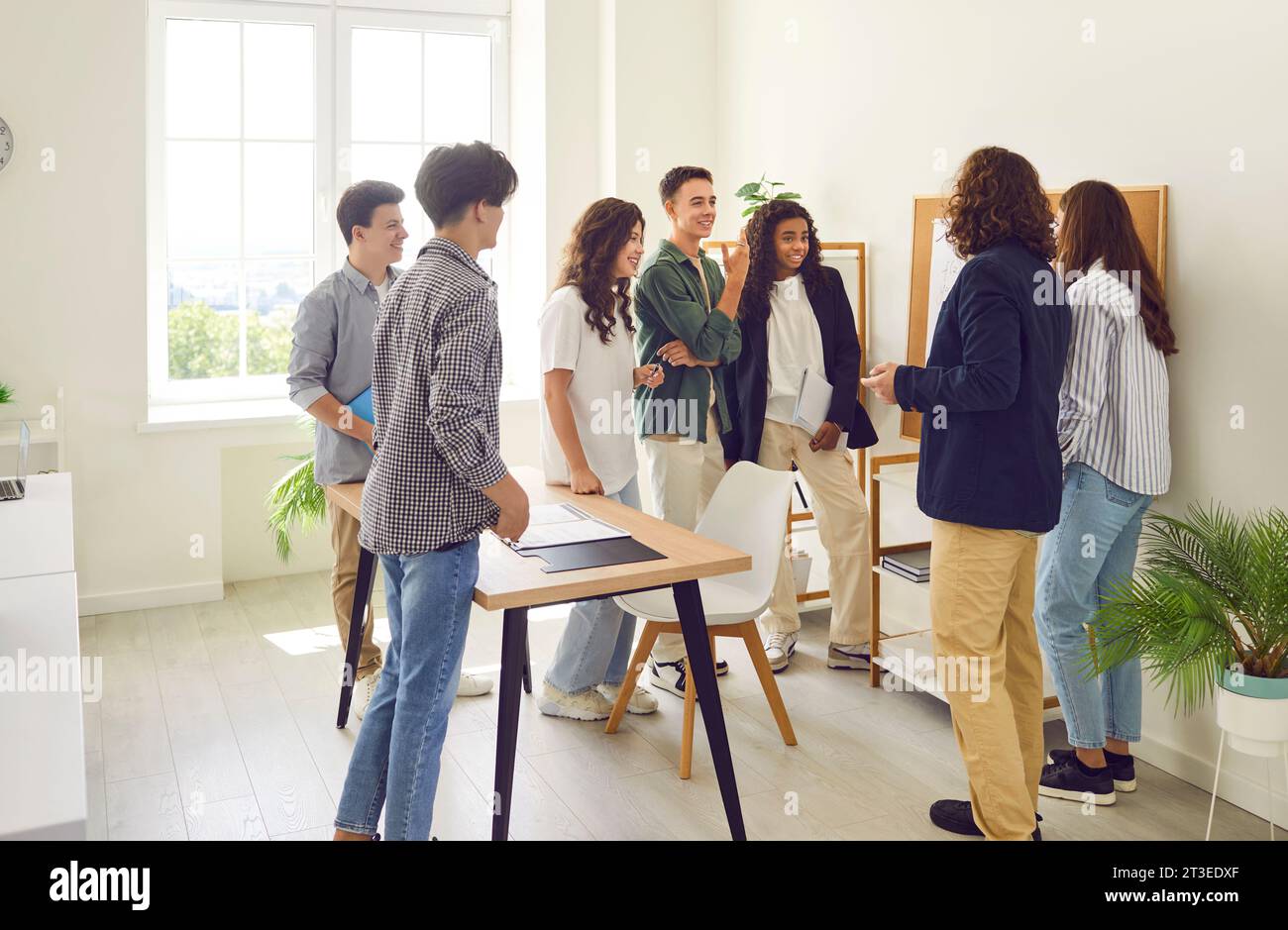 Young teacher standing in a circle with college or high school students ...
