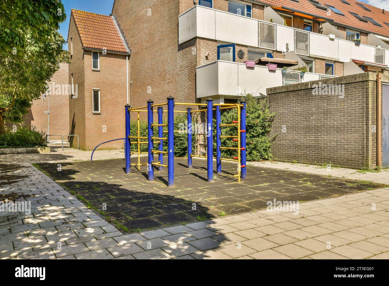 an outdoor play area in front of a brick building with blue and yellow ...