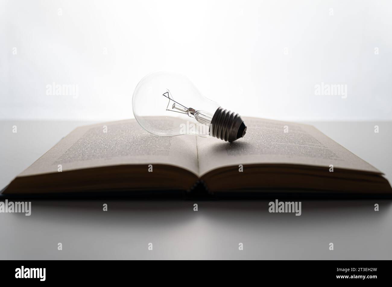 Open book, backlit, with light bulb above. Idea, study, creativity and ...
