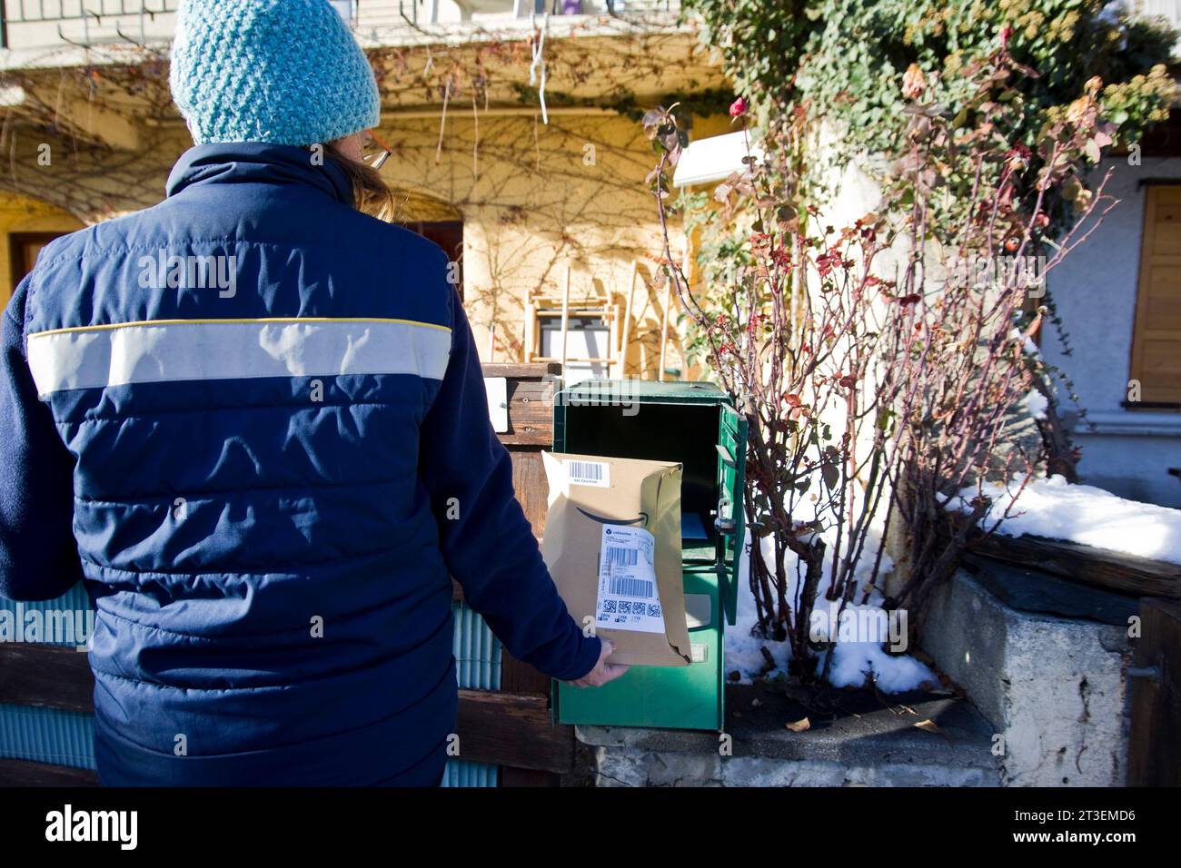 Mailwoman dropping off an Amazon parcel in a mailbox Stock Photo - Alamy