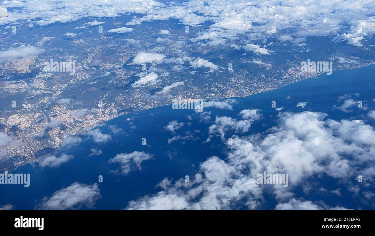 Aerial view above clouds from airplane window with blue sky. Portogal ...