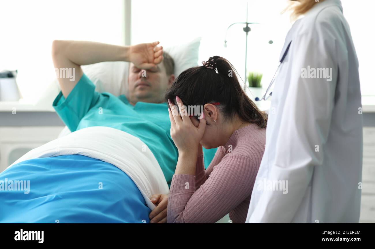 Girl crying near man lying on bed in ward clinic Stock Photo - Alamy