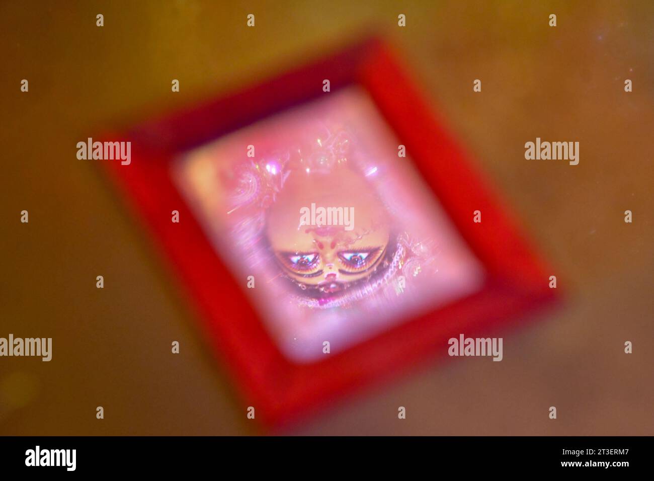 A reflection of the Hindu Goddess Durga on a mirror during a ritual on ...