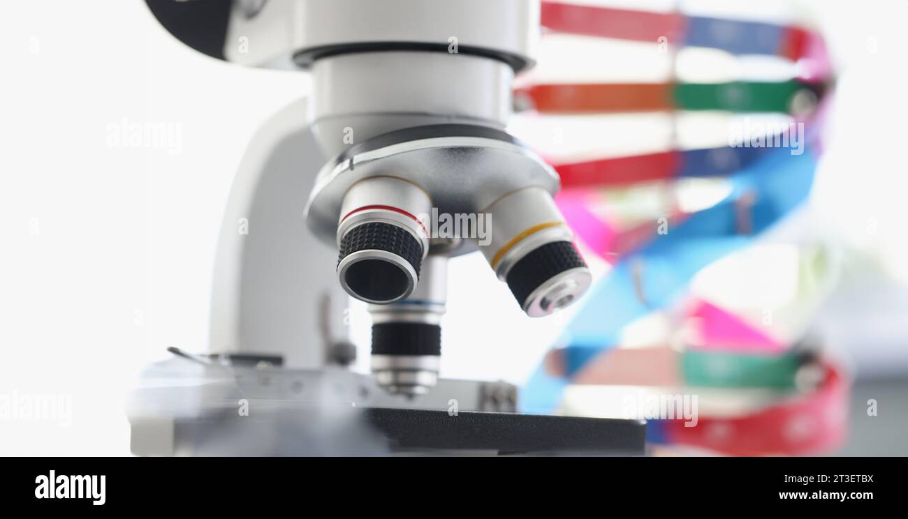 Microscope standing near multicolored model of dna chain in lab Stock ...