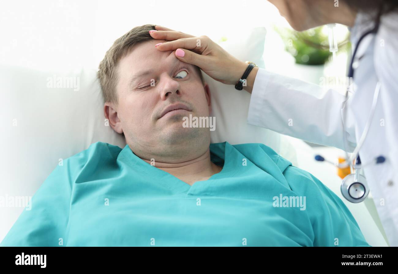Doctor opens his eyes to patient unconscious clinic Stock Photo - Alamy