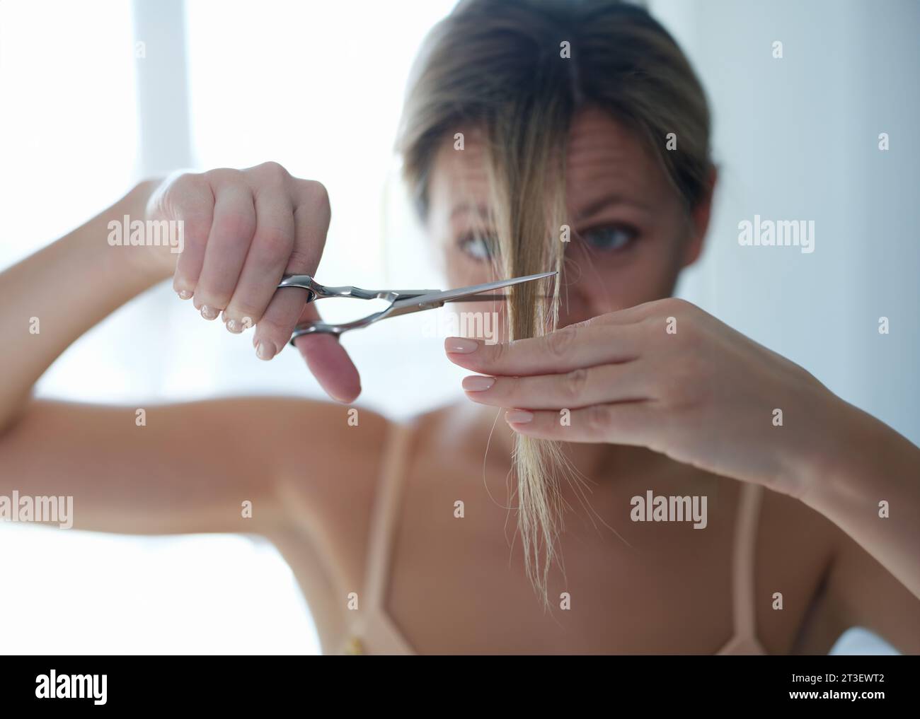 Young woman cutting off her bangs with scissors closeup Stock Photo - Alamy