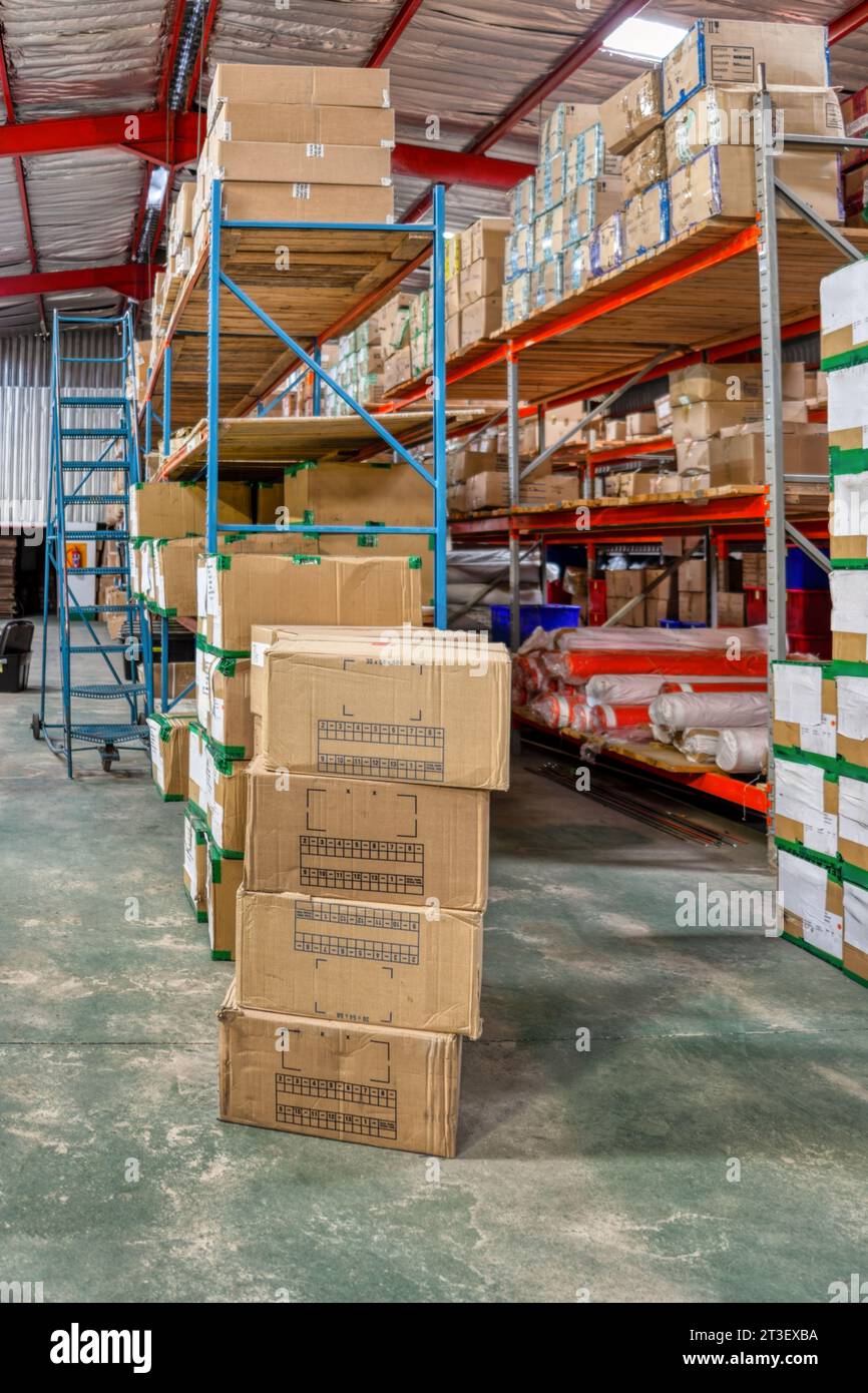 huge warehouse with carton boxes and rolls of textile material in ...