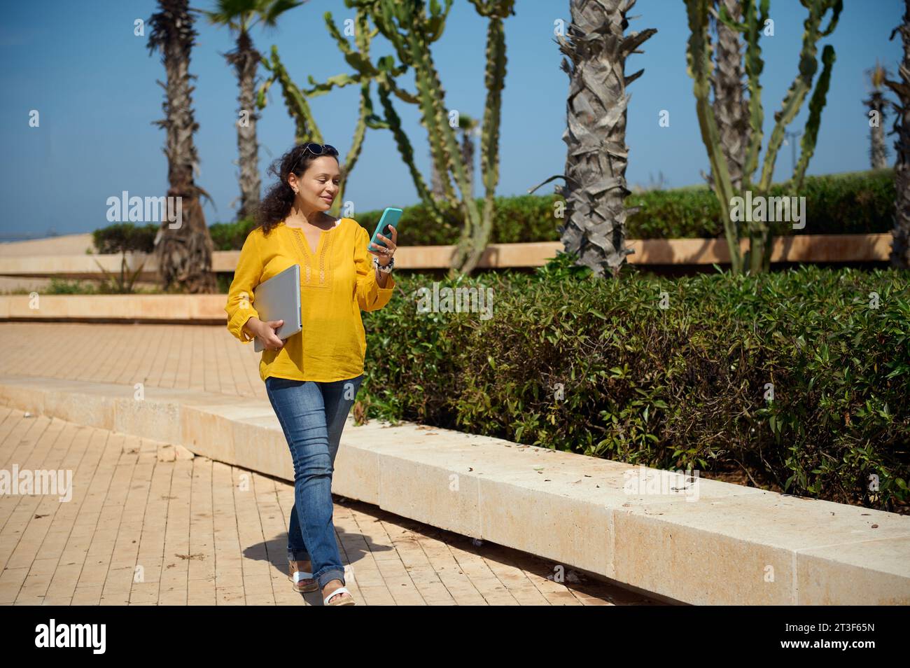 Confident young woman walking palm hi-res stock photography and images ...