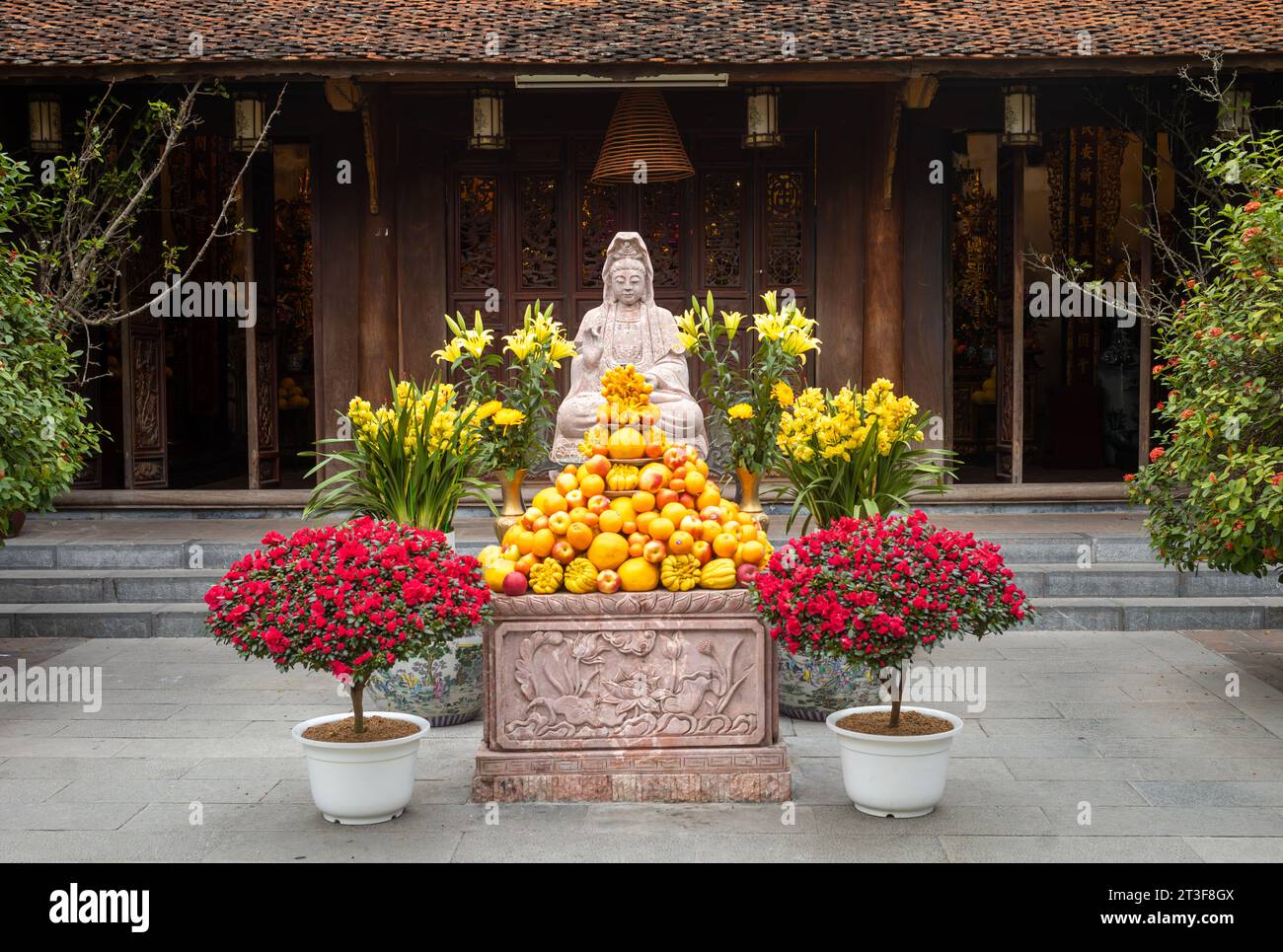 A Buddhist shrine decorated with flowers and fruit in front of Dien Huu ...
