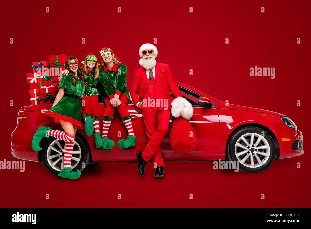 Photo of excited funny santa claus helpers smiling riding car ...