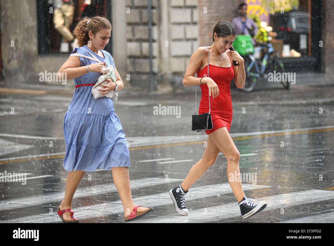 Italian young girls crossing the street in the rain. Via Ugo Bassi ...