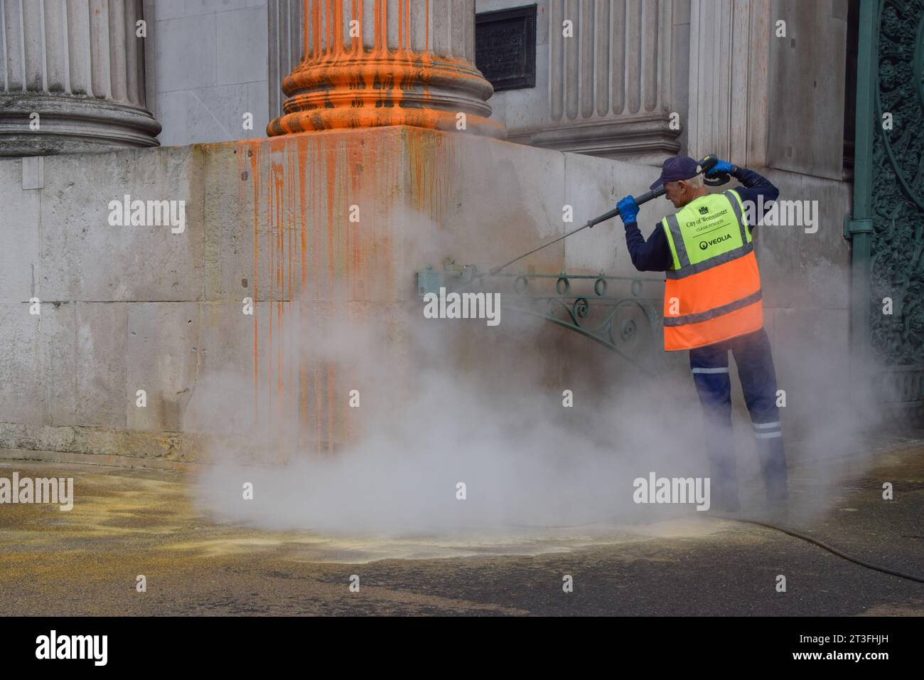 London, England, UK. 25th Oct, 2023. A worker cleans the orange paint ...