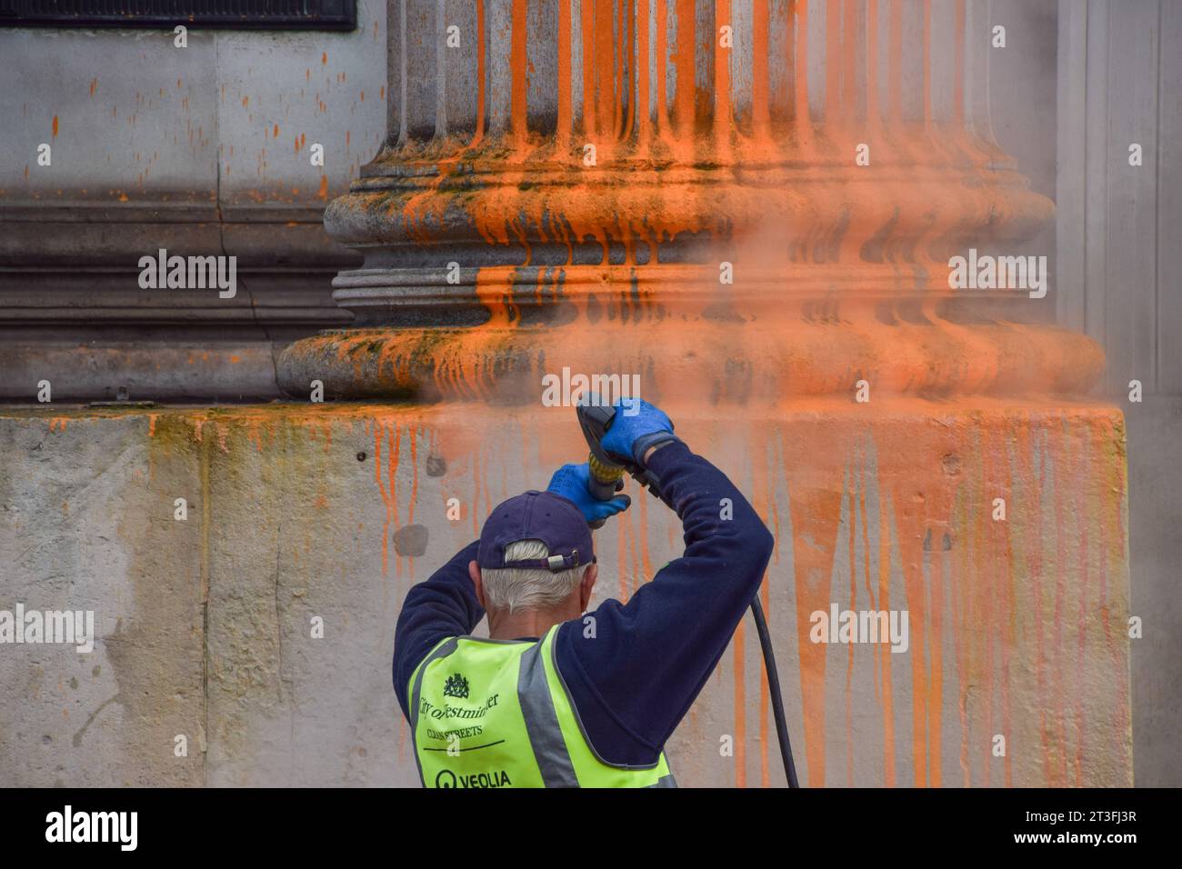 London, England, UK. 25th Oct, 2023. A worker cleans the orange paint ...
