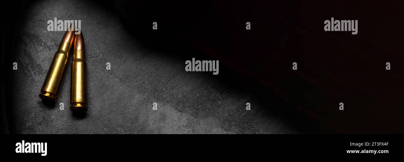 Two bullets for Kalashnikov assault rifle on gray concrete and gradient ...